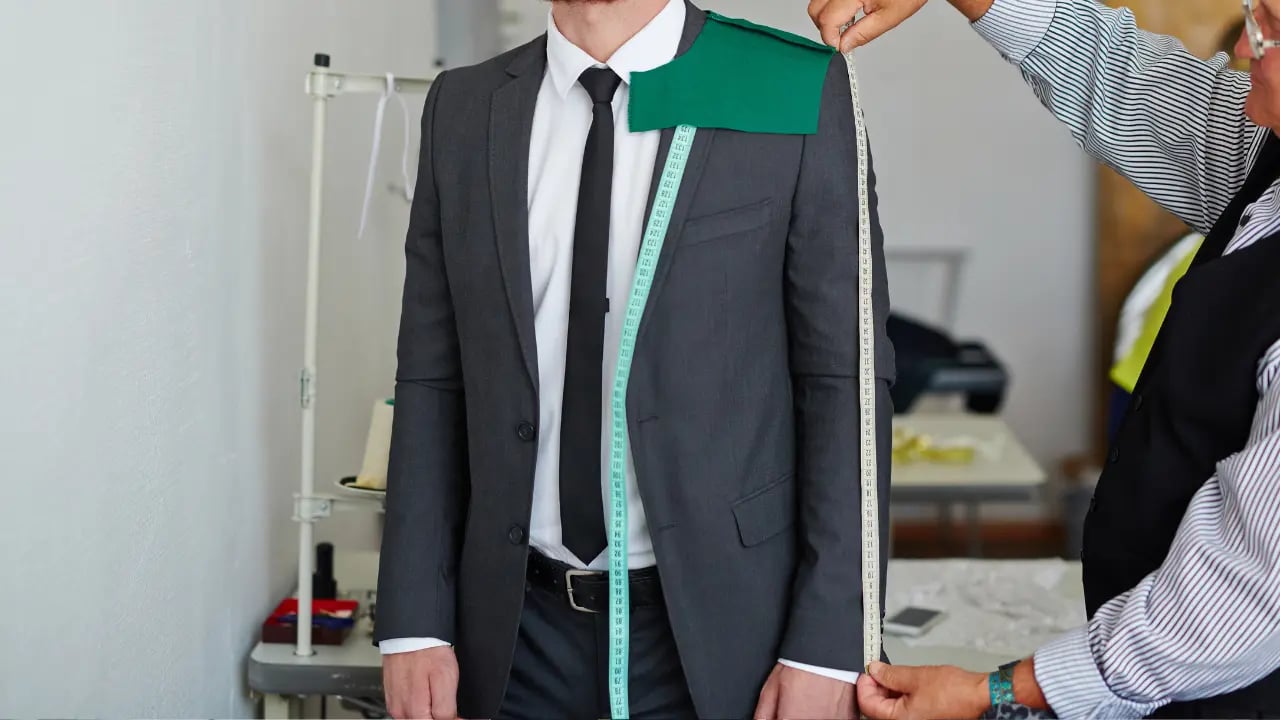 a person measuring the sleeve length fr the suit