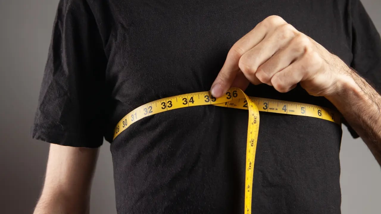 A person measuring a chest of a man